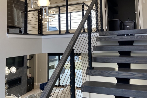 mono stringer staircase with dark wood tread and cable railing