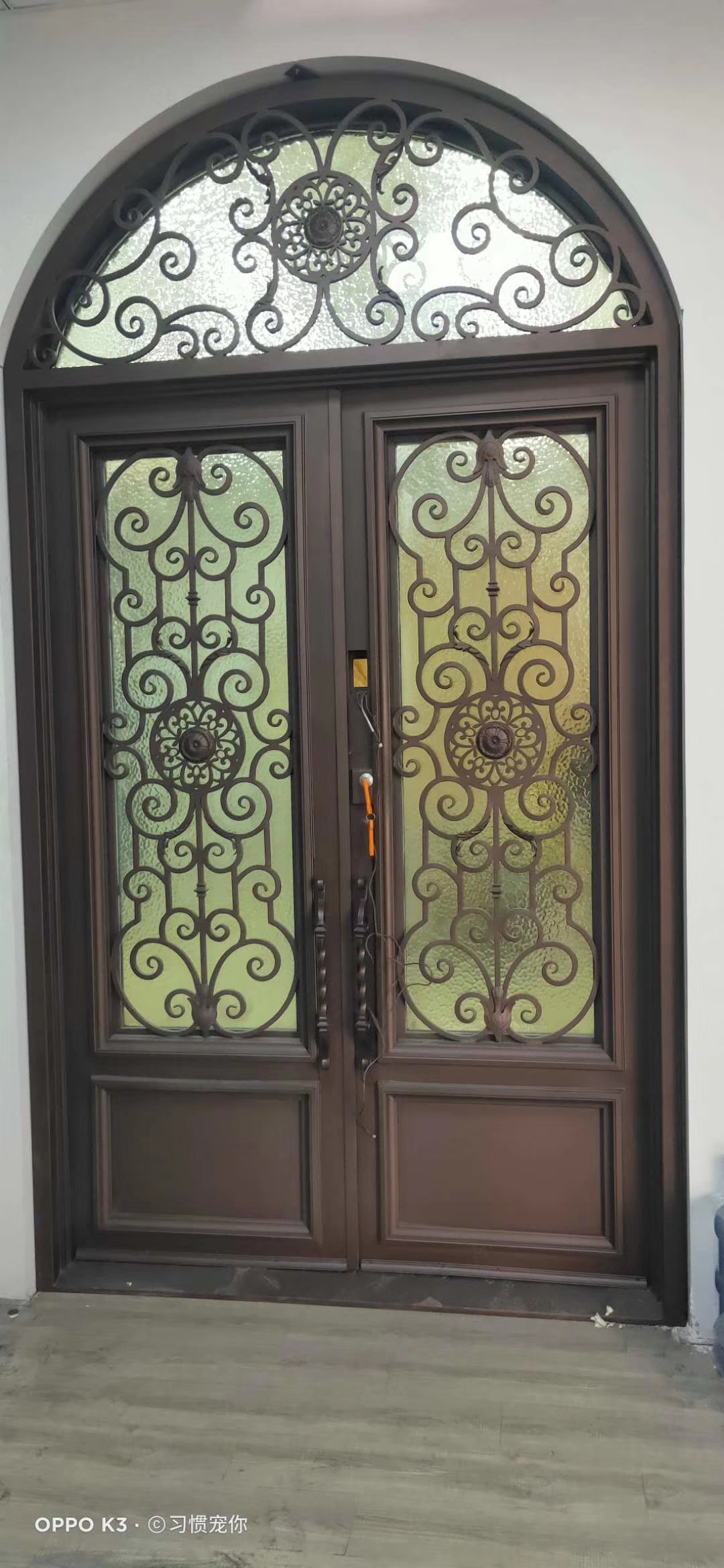 Double panel wrought iron front entry door with arc top in brown color ...